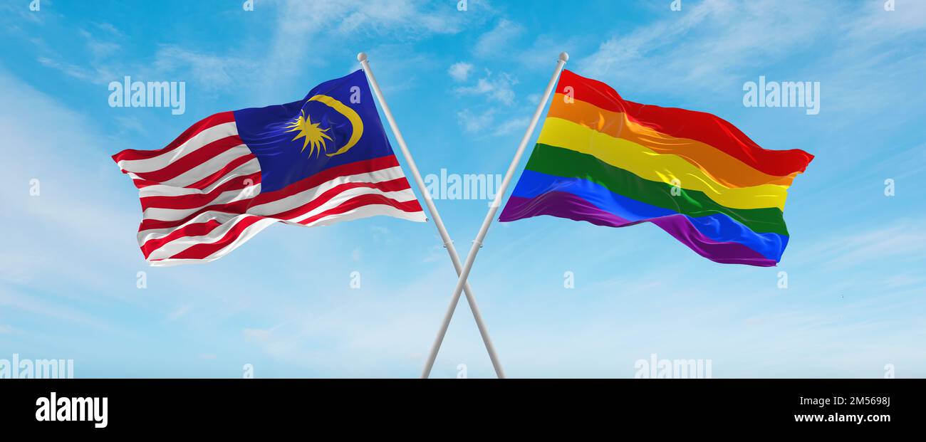 two crossed flags LGBT Pride and Malaysia waving in wind at cloudy sky ...