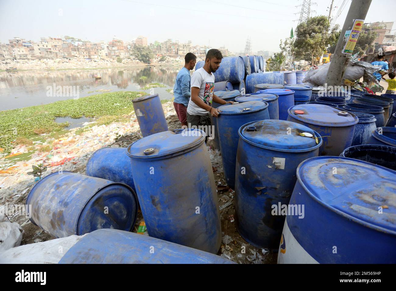 Worker seen washing empty oil drums for recycling at a warehouse the ...