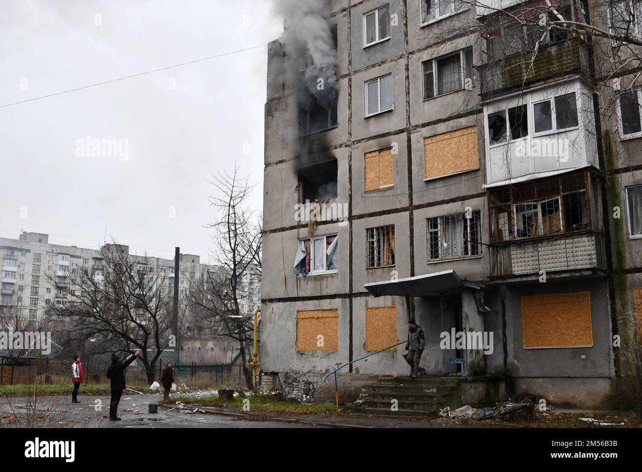 Bakhmut, Ukraine. 16th Dec, 2022. Local residents look at a burning ...