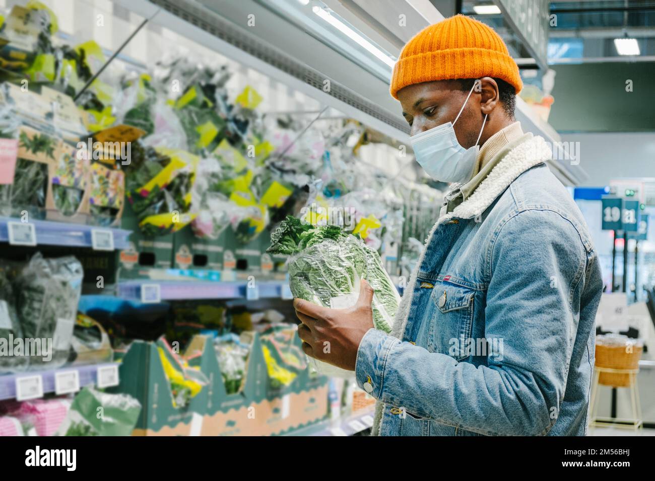 Black man shopper in orange hat with protective mask chooses Chinese ...