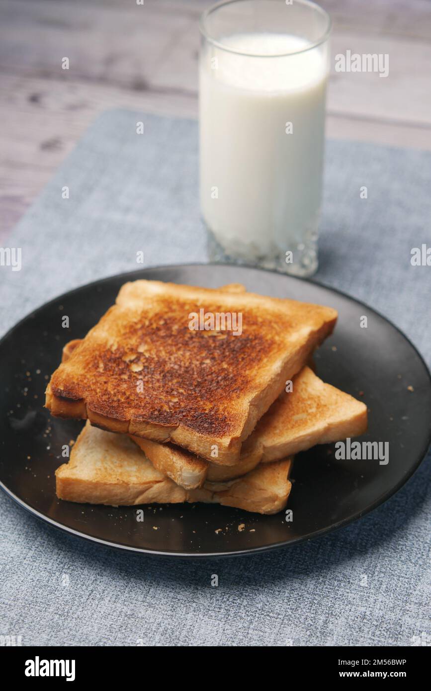 glass of milk and toasted bread on table Stock Photo - Alamy