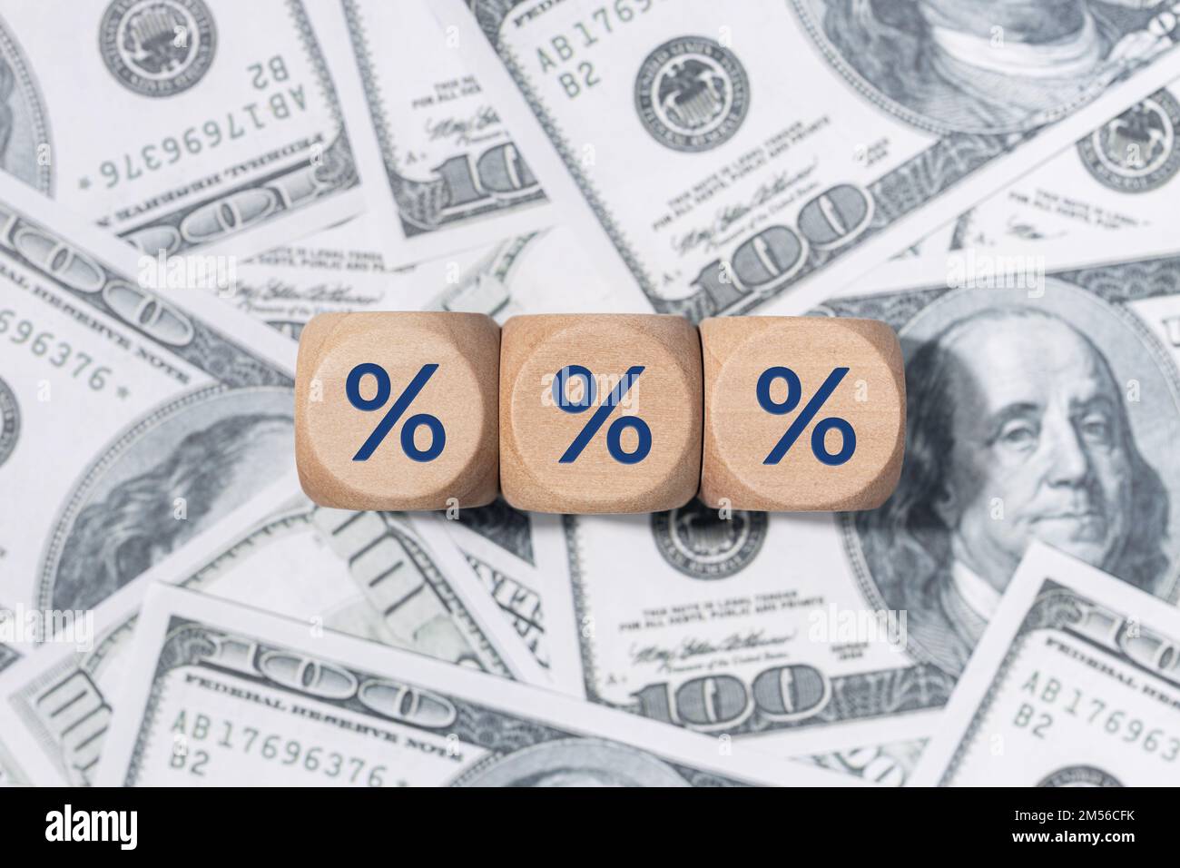 Percentage sign on wooden blocks and US dollar bills background ...