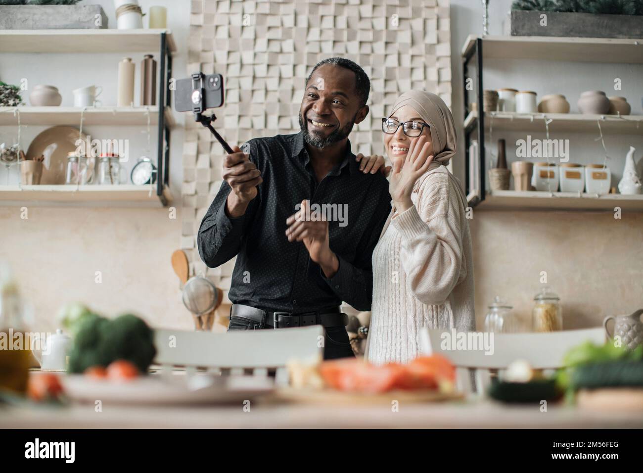 Multiethnic family having video call using selfie stick while providing ...