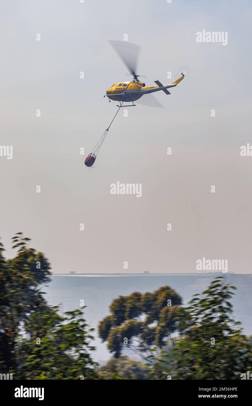 A vertical shot of a firefighting helicopter extinguishes a fire Stock ...
