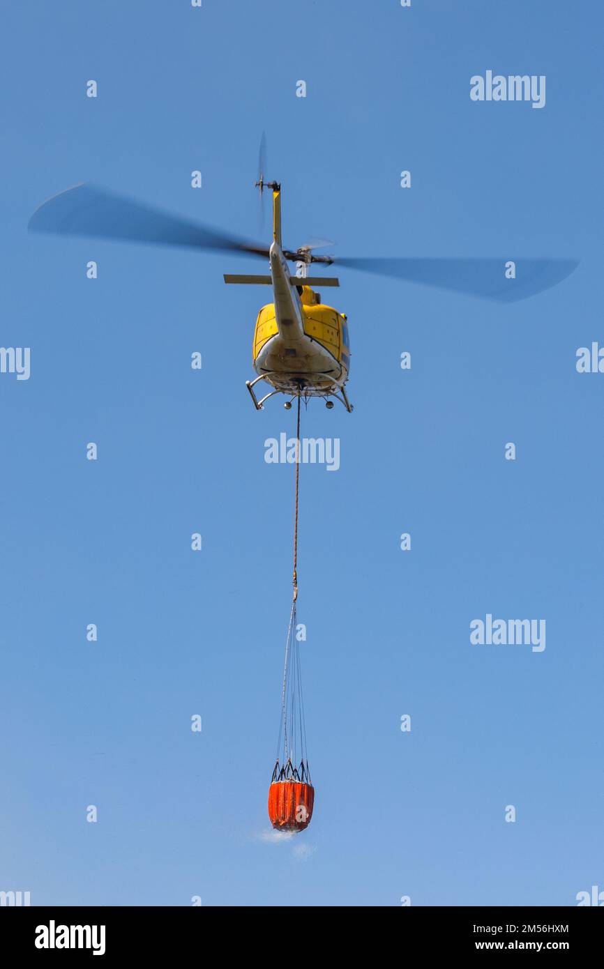 A vertical shot of a firefighting helicopter extinguishes a fire Stock ...