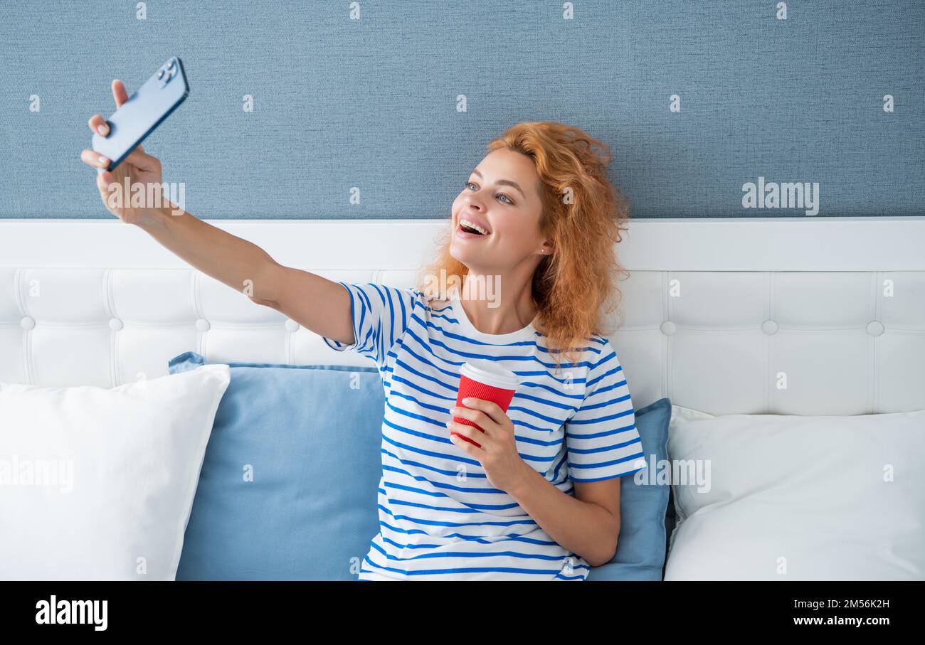 cheerful woman blogger with coffee making selfie on phone. selfie time ...