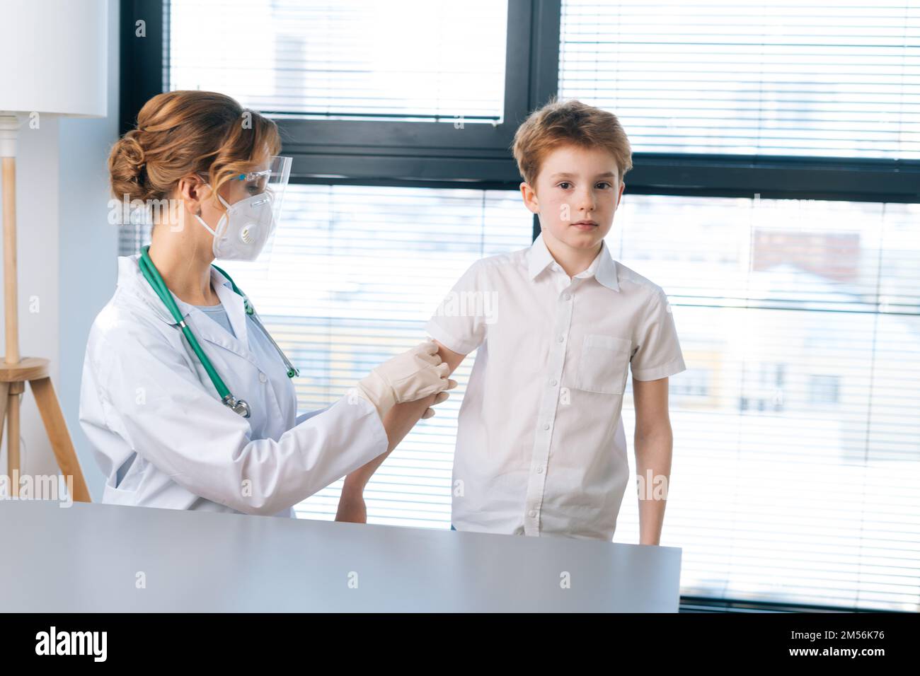 Portrait of female doctor wearing white uniform applying plaster on ...
