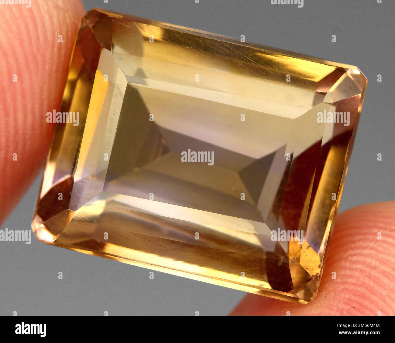 Natural stone bi color ametrine on gray background Stock Photo - Alamy