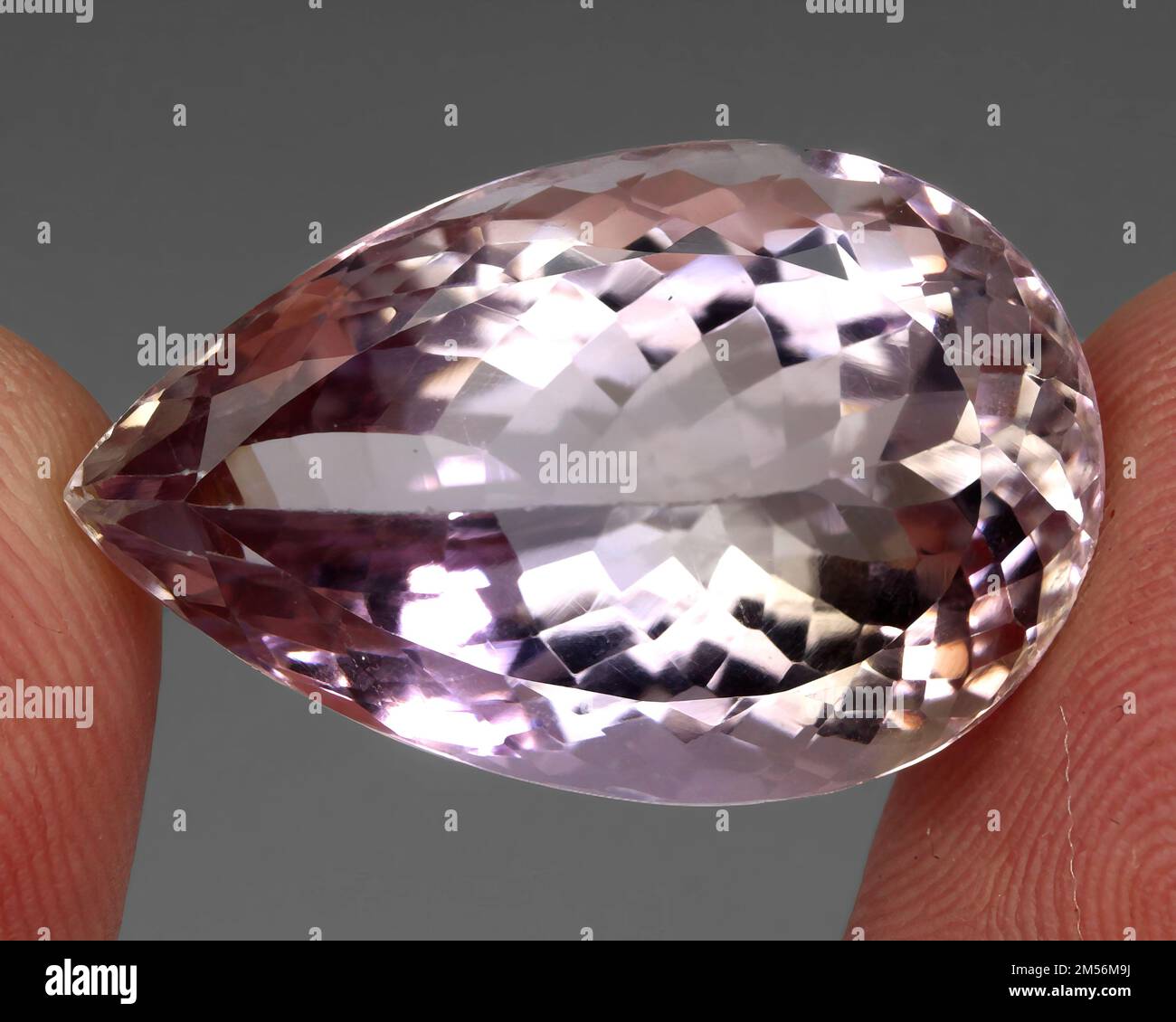 Natural stone bi color ametrine on gray background Stock Photo - Alamy