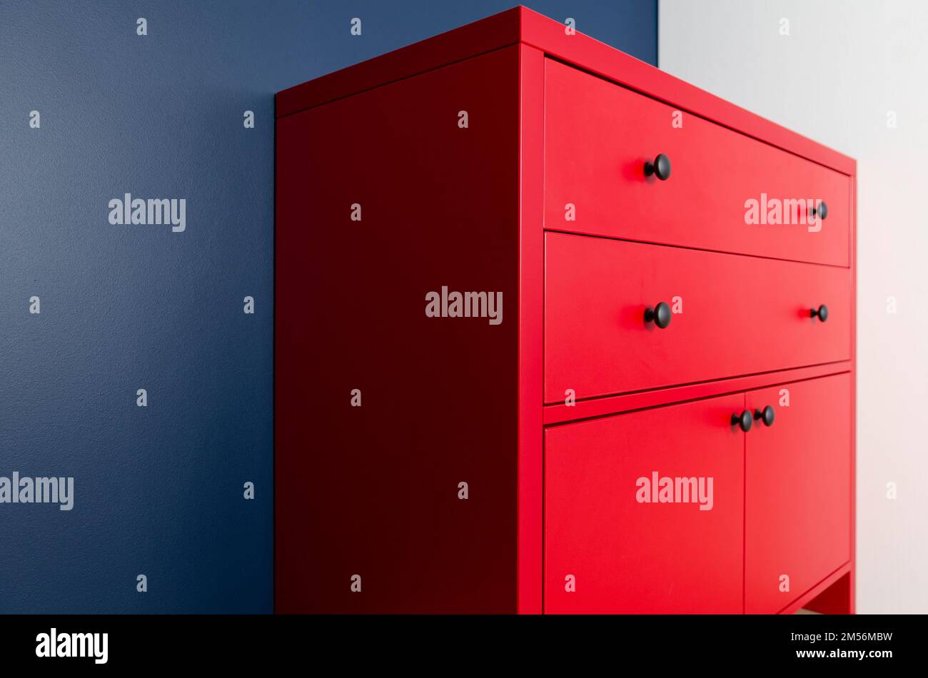 New red chest of drawers in the interior of the apartment against the ...