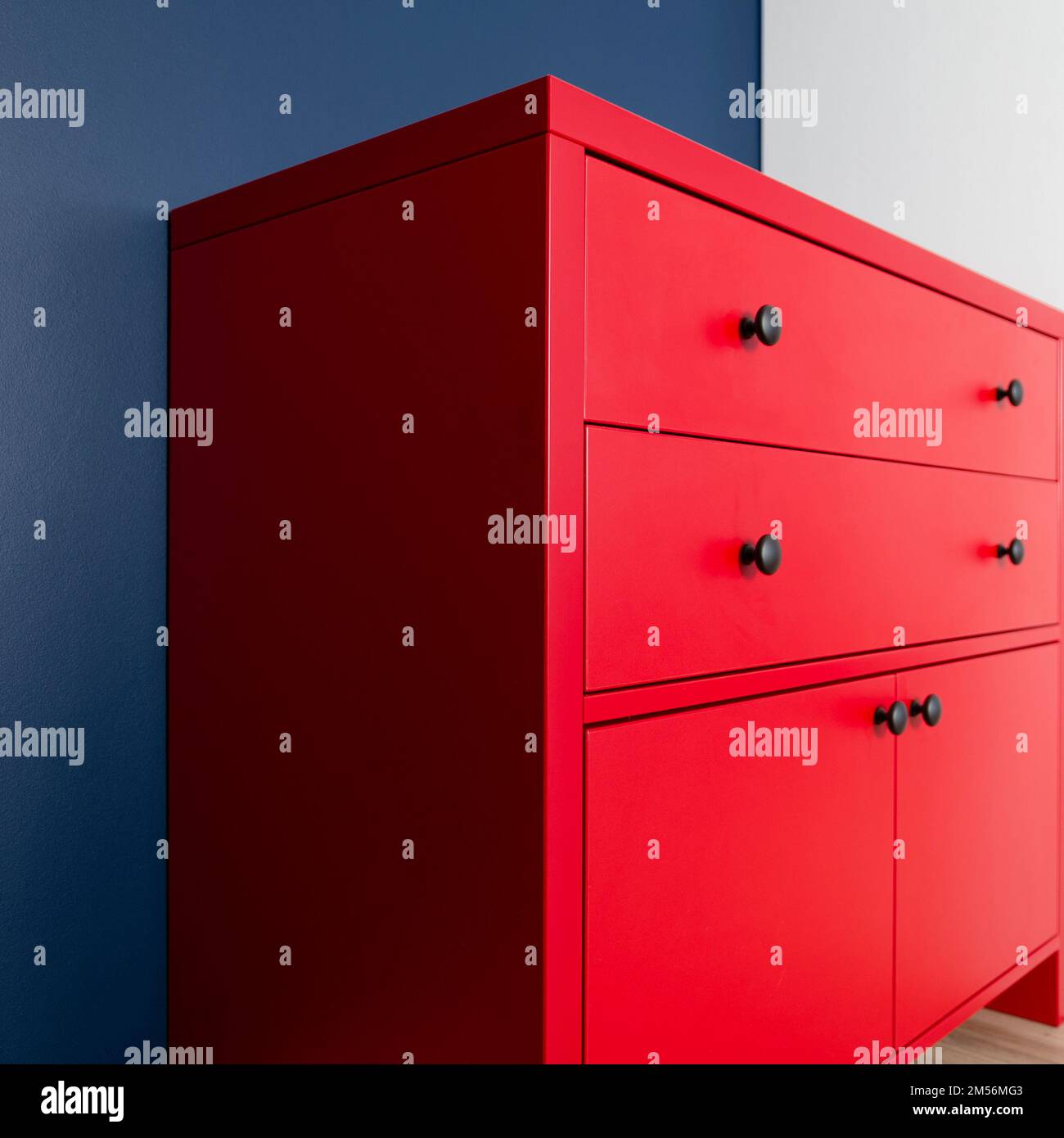 New red chest of drawers in the interior of the apartment against the ...