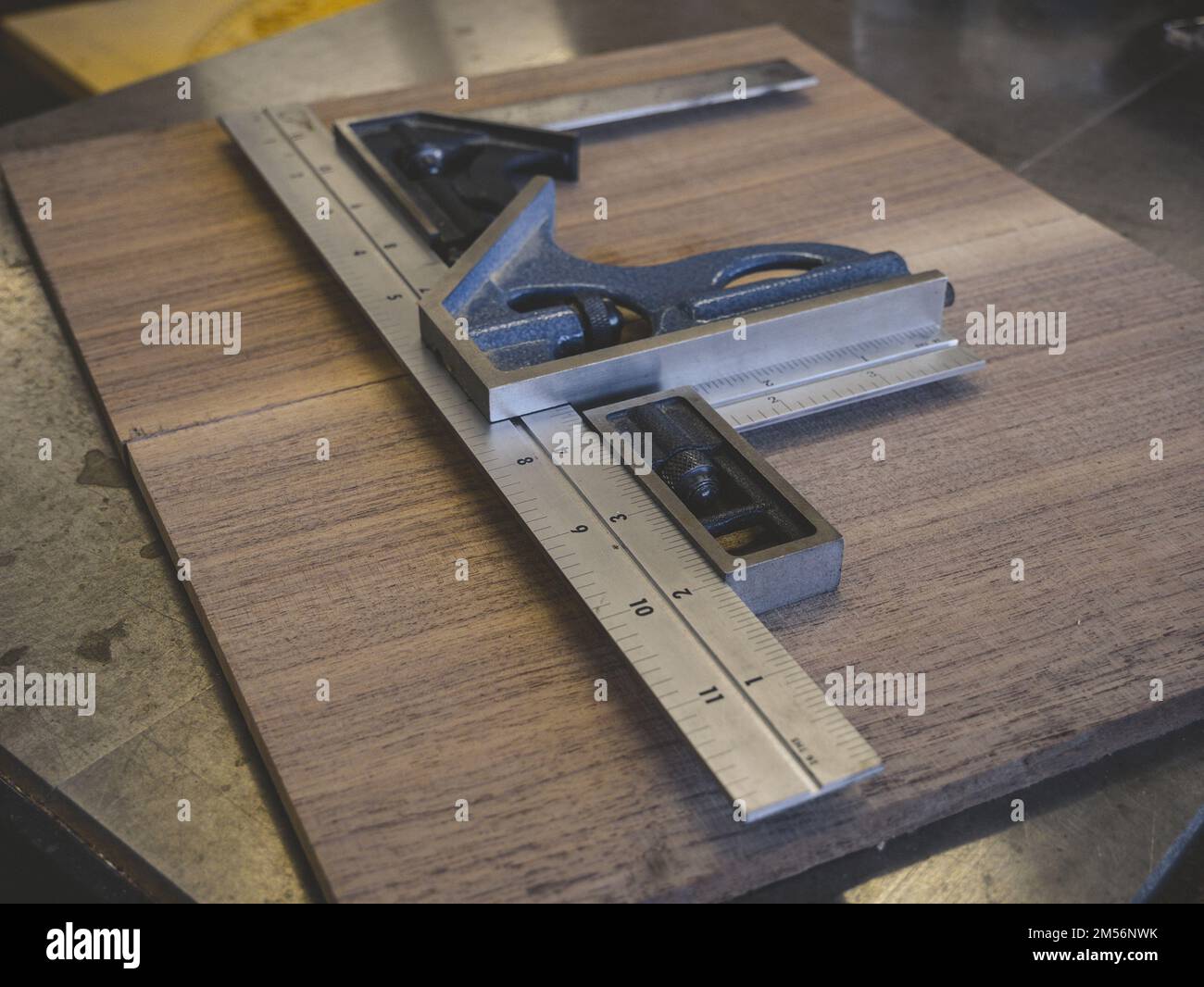 A rulers sitting on walnut wood waiting to be used in the woodshop ...
