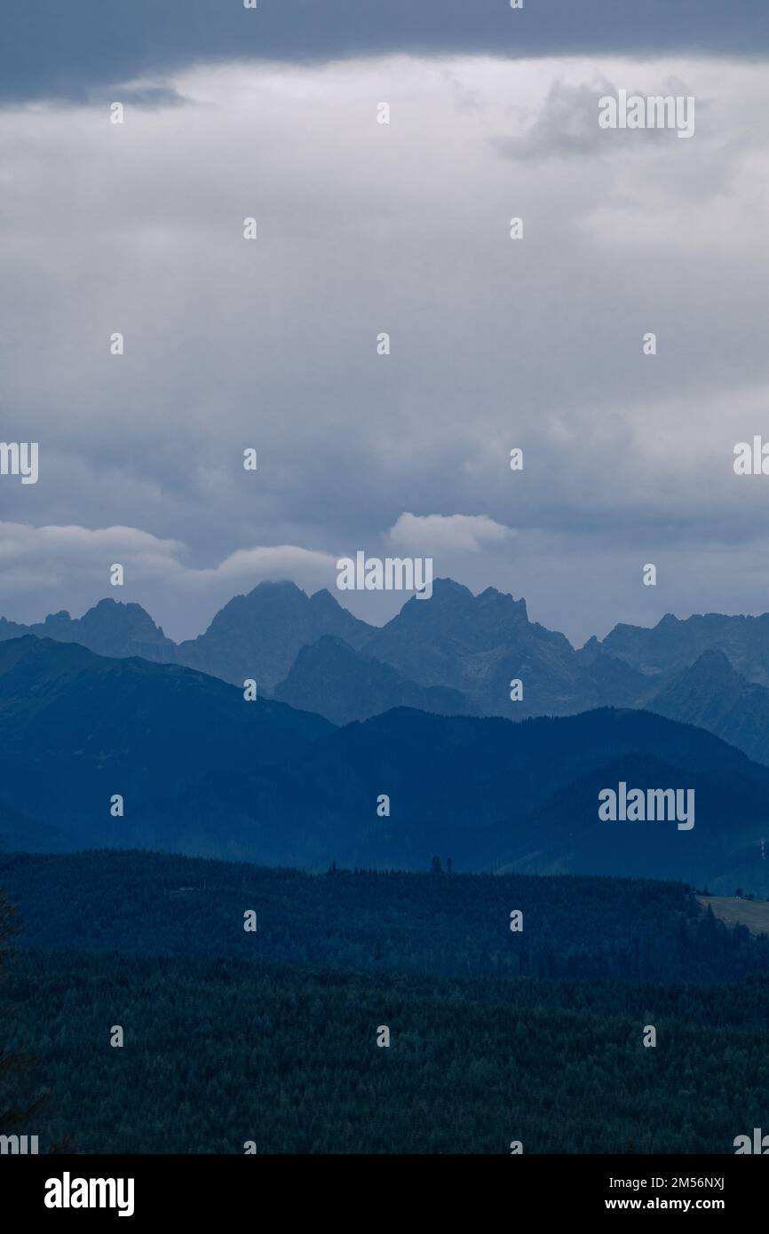 The layers of a mountain range in shades of blue, vertical Stock Photo ...