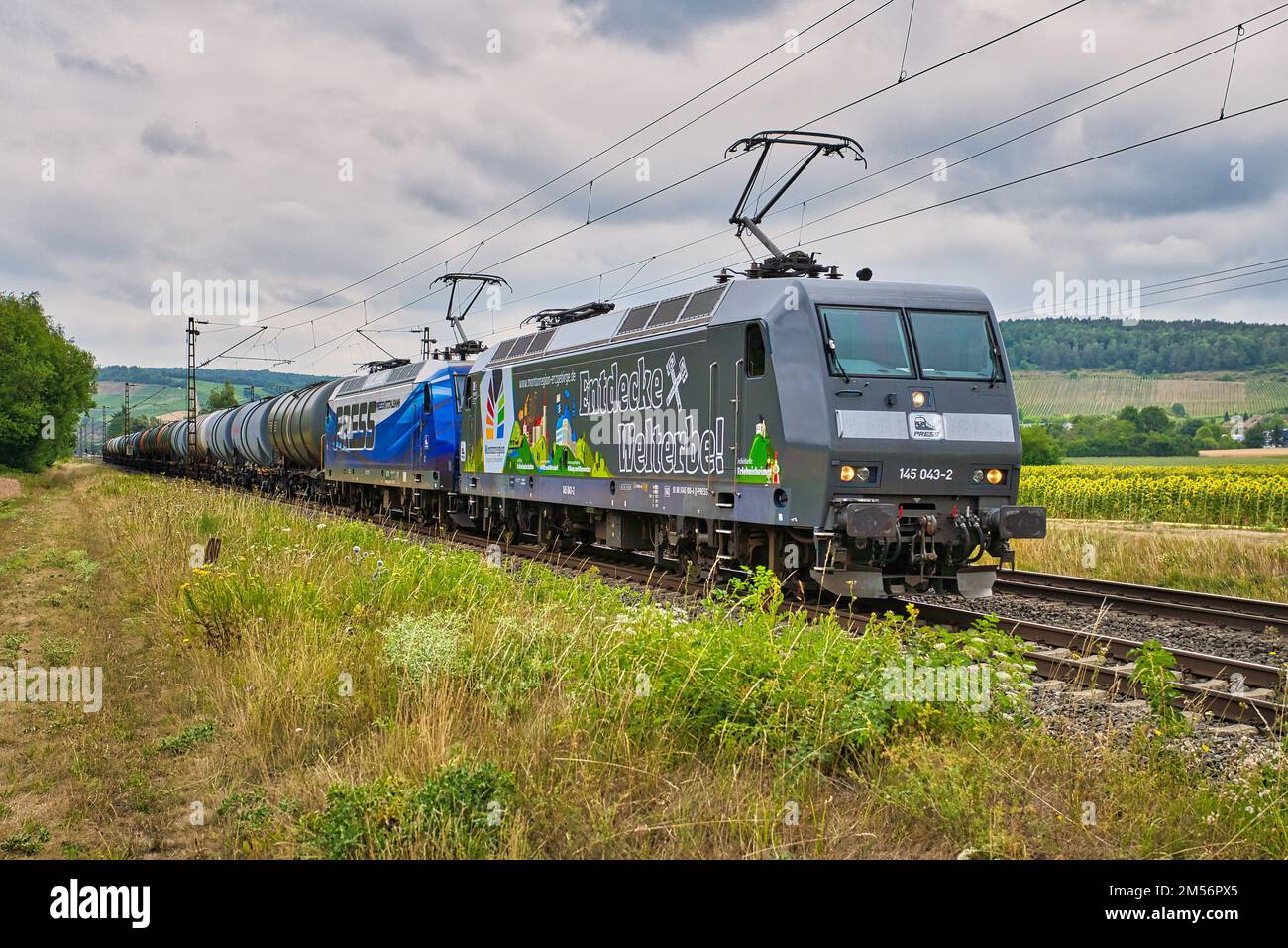 An electric locomotive pulling a tank car train with a double traction ...