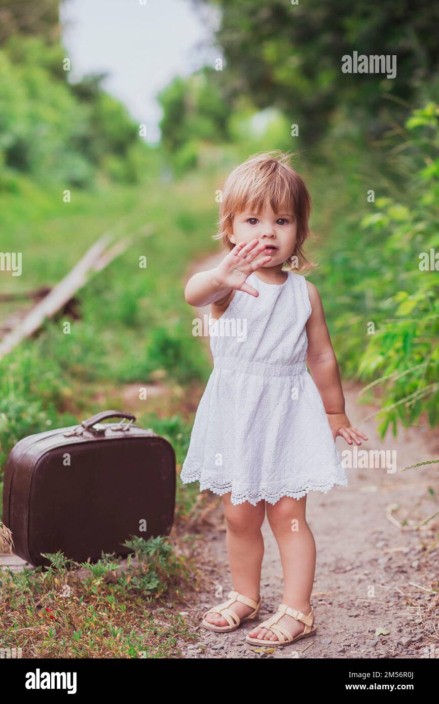 Charming baby waving goodbye near the railroad Stock Photo - Alamy
