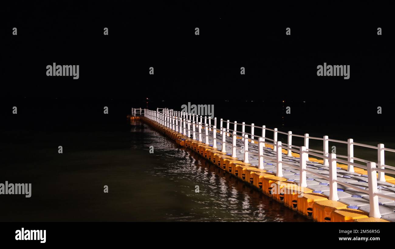 A plastic modular floating pontoon bridge over the lake at night Stock ...