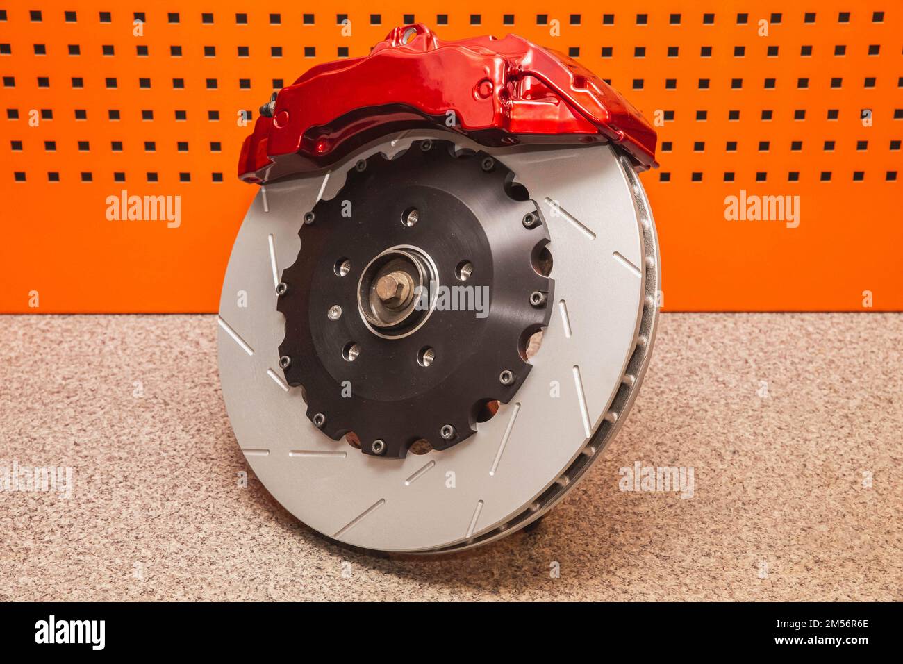 steel brake disc and red sports support on the table in the workshop ...