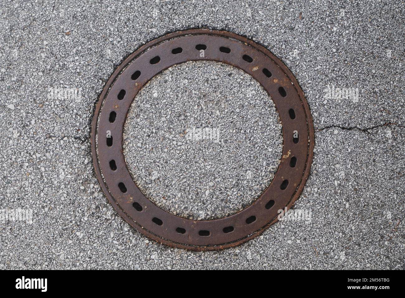 Sewer hatch disguised as asphalt in Slovenia Stock Photo - Alamy