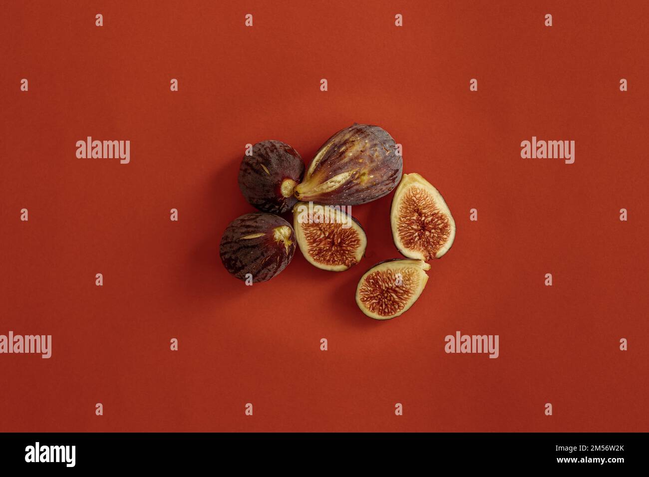 A top view of fig fruits on red background Stock Photo - Alamy