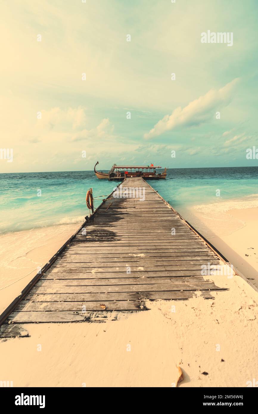 A vertical capture of a wooden promenade partially covered with sand ...