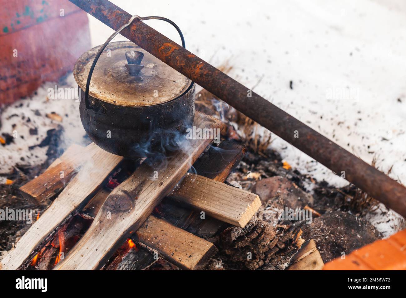 Boiling cauldron with tourist soup hangs over an open fire, camping ...