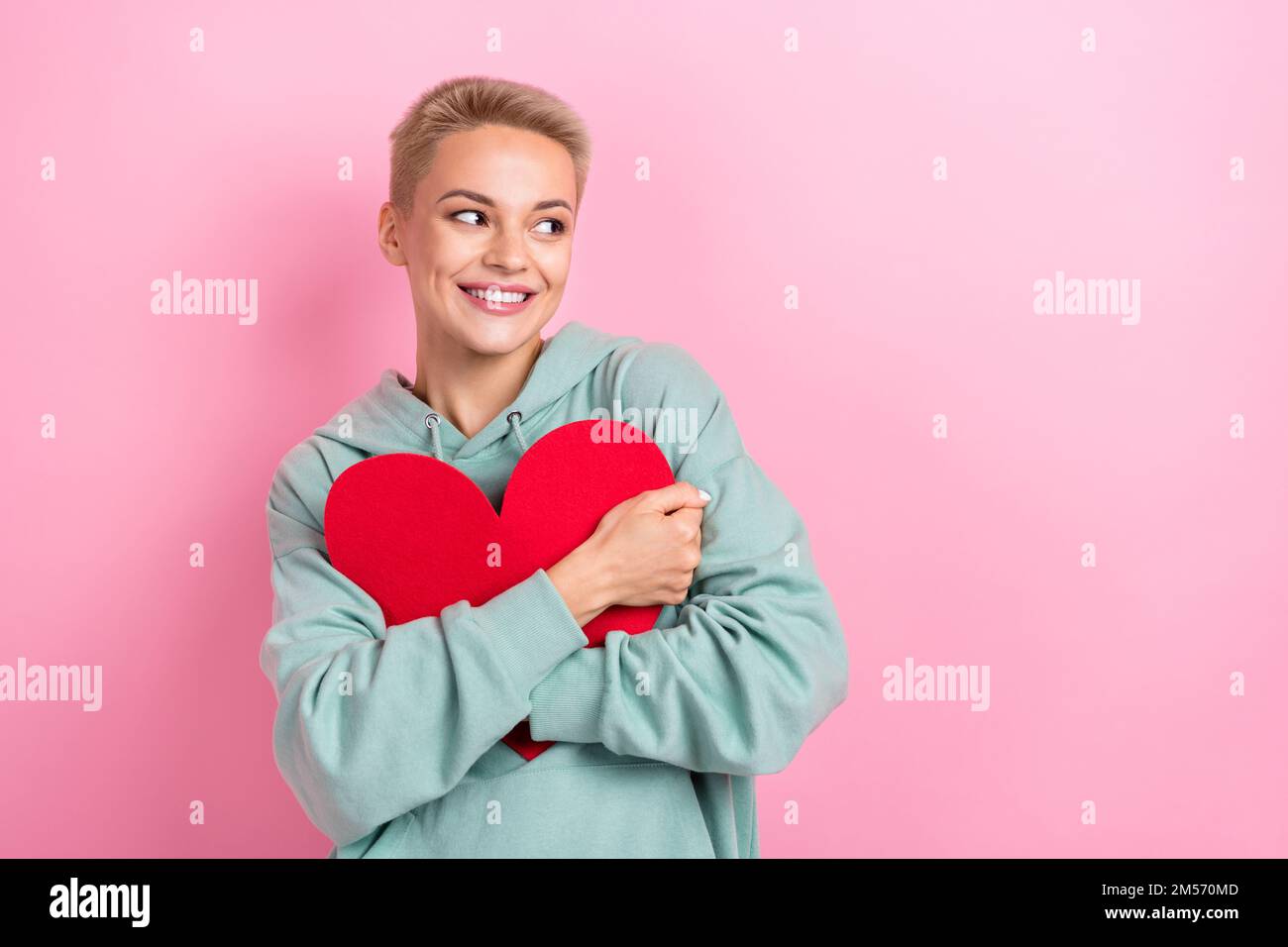 Photo portrait of pretty young girl cuddle big red heart look empty ...