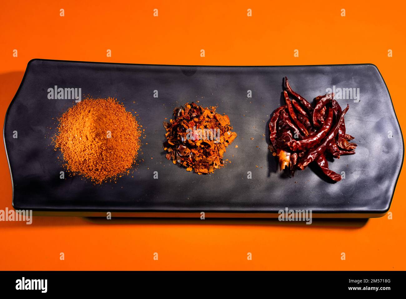 A top view of dry red chilli, chilli flakes, and red chilli powder on a ...