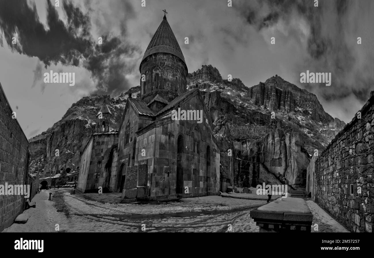 A beautiful grayscale of a medieval monastery of Geghard carved out of ...