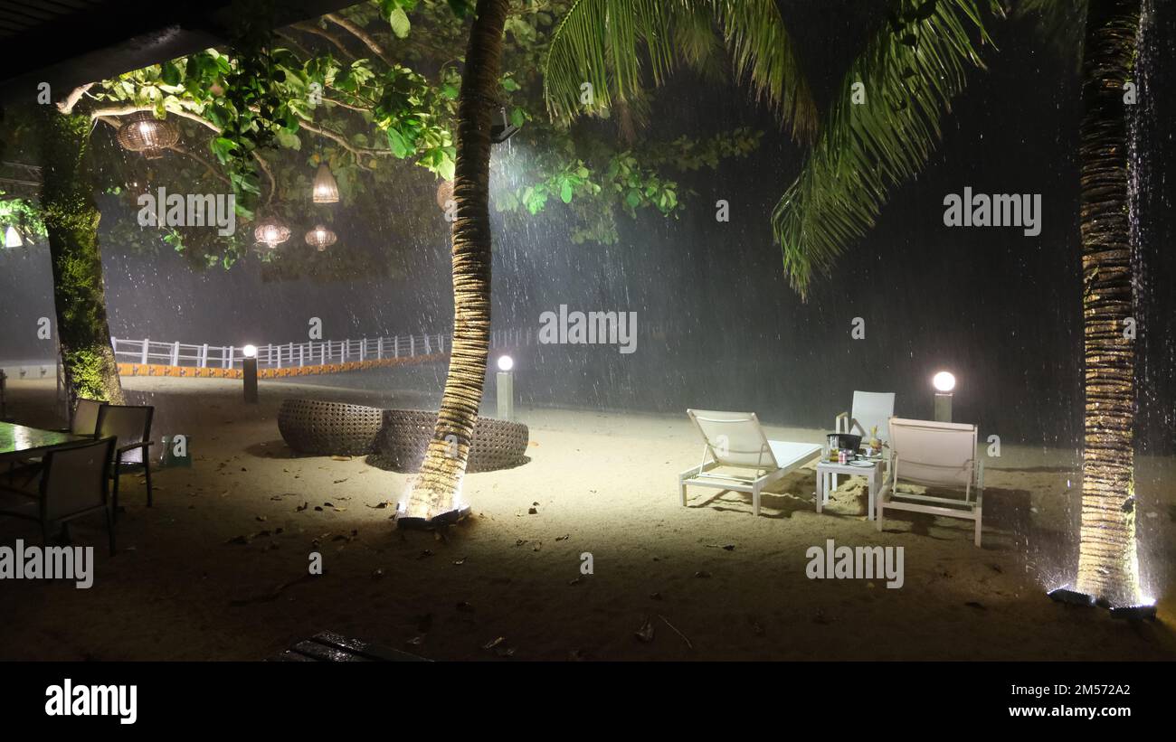A rain pouring down in a vacation destination with palm trees and ...