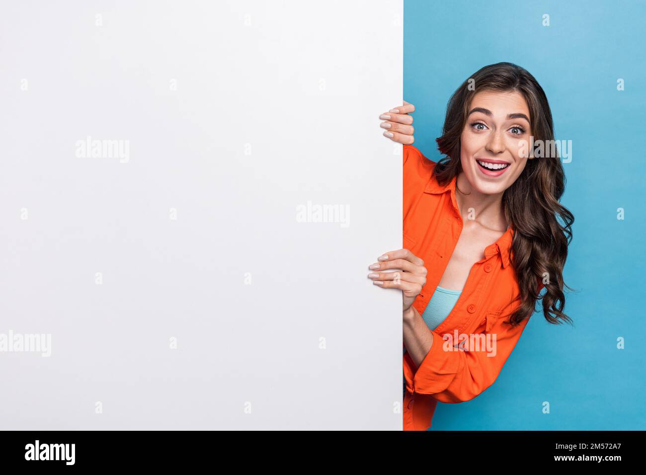 Photo portrait of young attractive woman hiding behind banner white ...