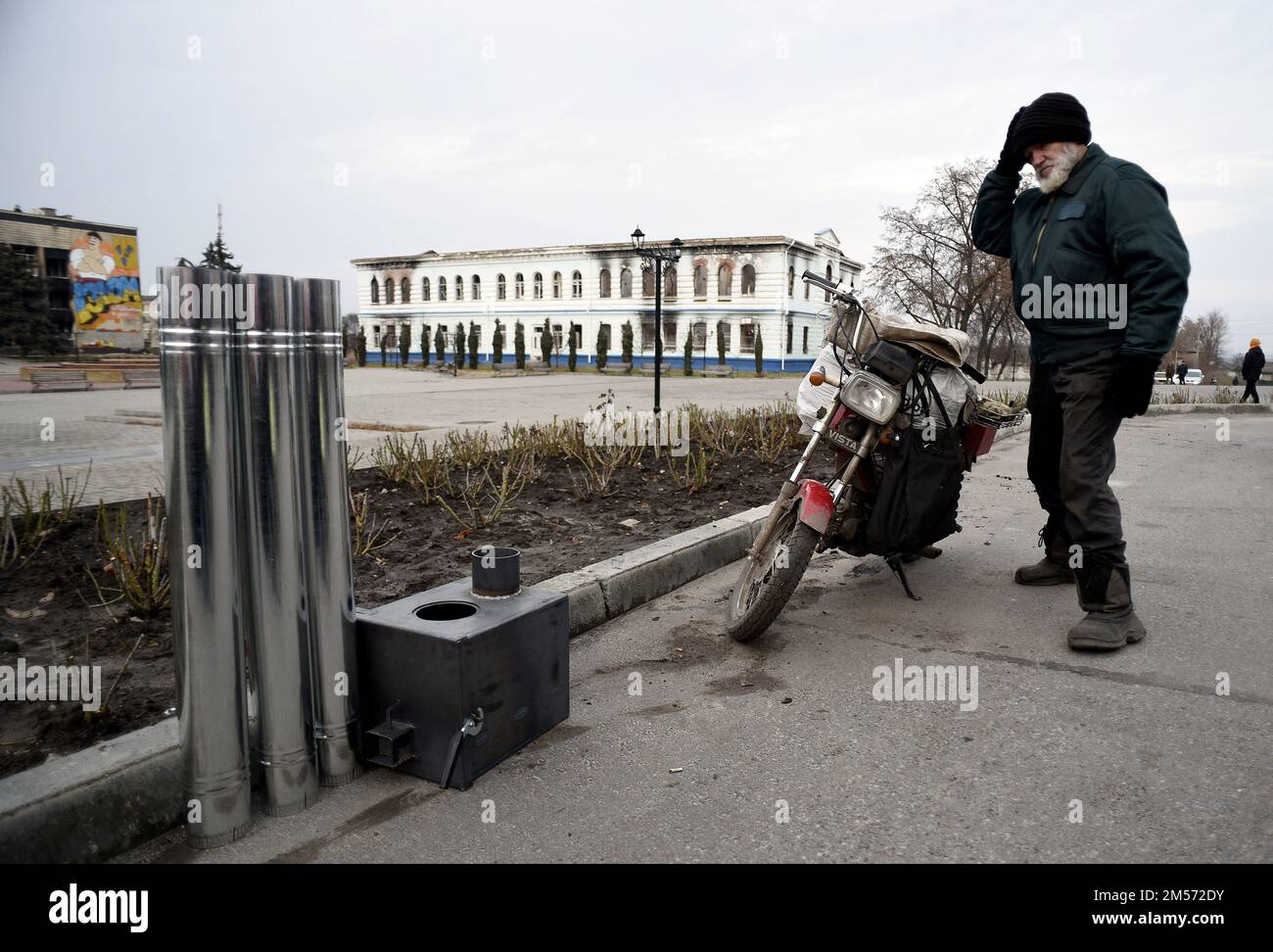 IZIUM, UKRAINE - DECEMBER 25, 2022 - A senior man looks at the parts of ...