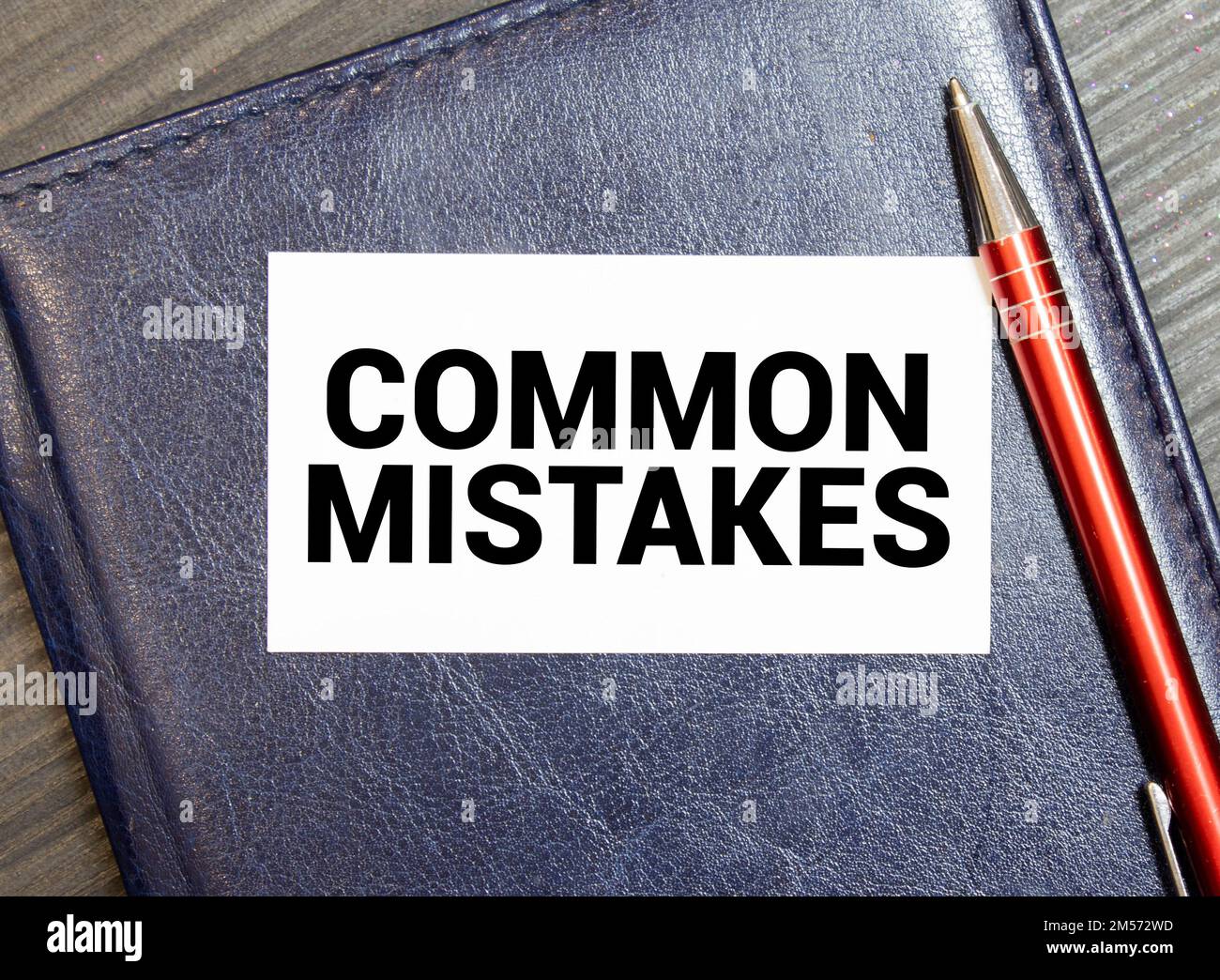 On a light background, a white notebook with the text COMMON MISTAKES ...