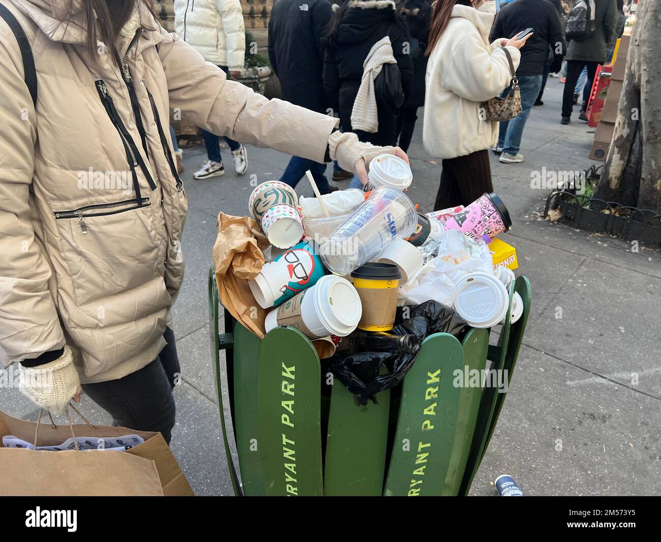 Overflowing garbage recepticles mostly filled with one use coffee cups ...