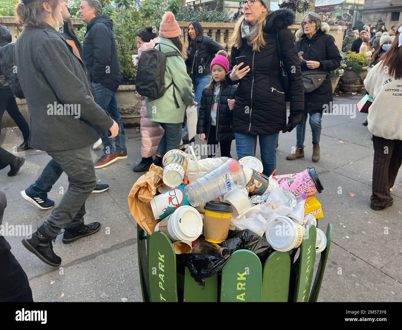 Overflowing garbage recepticles mostly filled with one use coffee cups ...