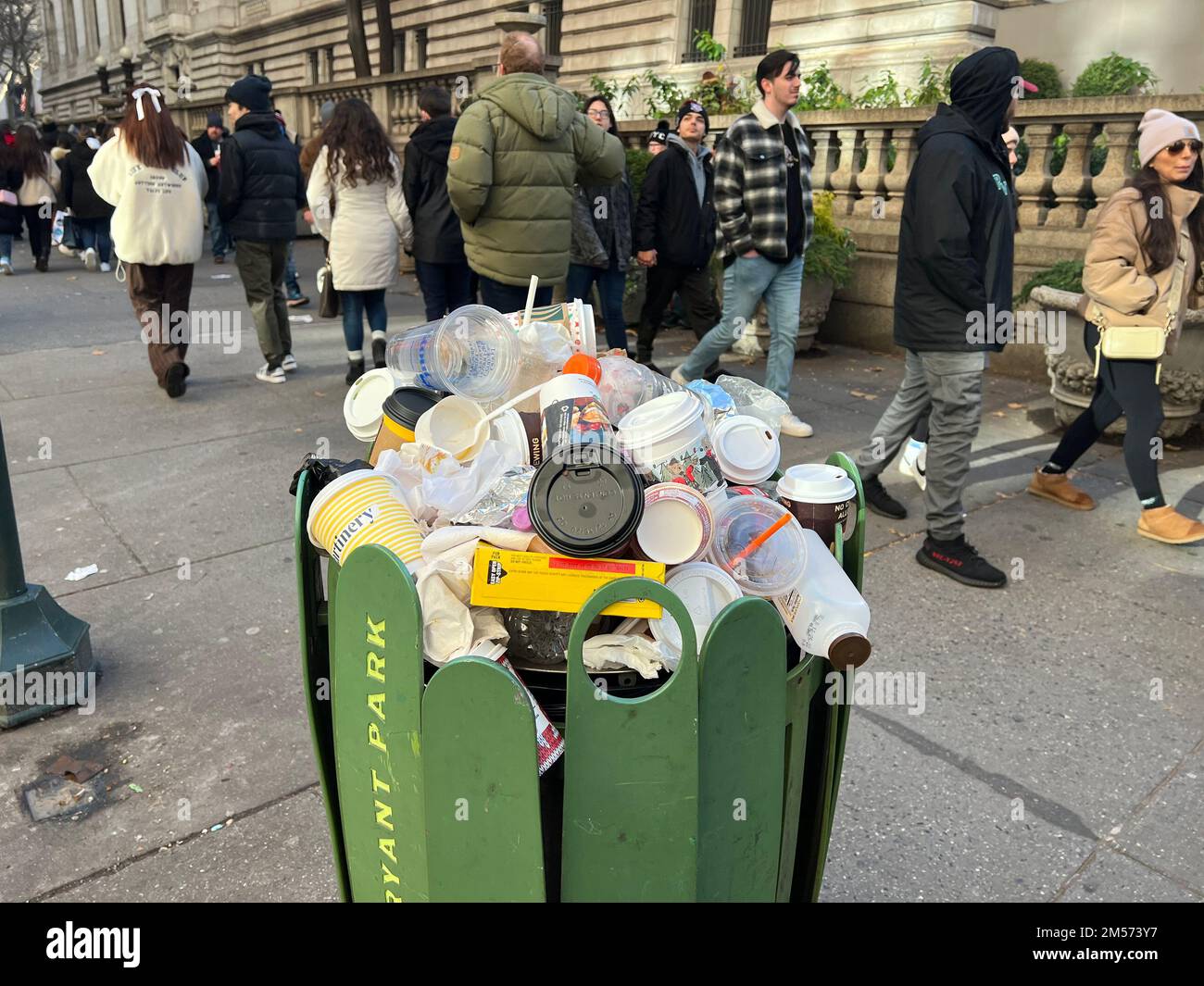 Overflowing garbage recepticles mostly filled with one use coffee cups ...