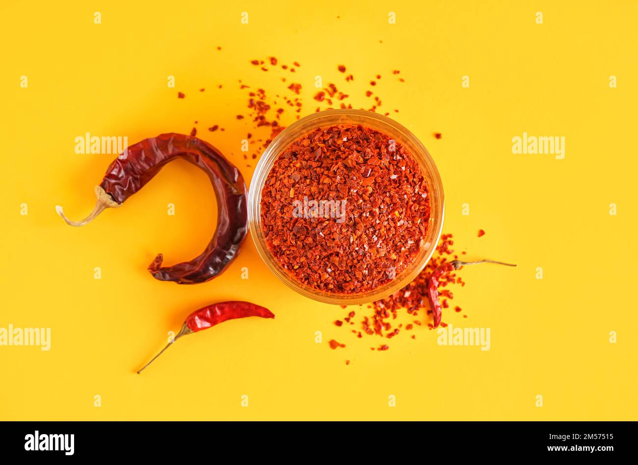 Bowl of chipotle chili flakes on color background Stock Photo - Alamy