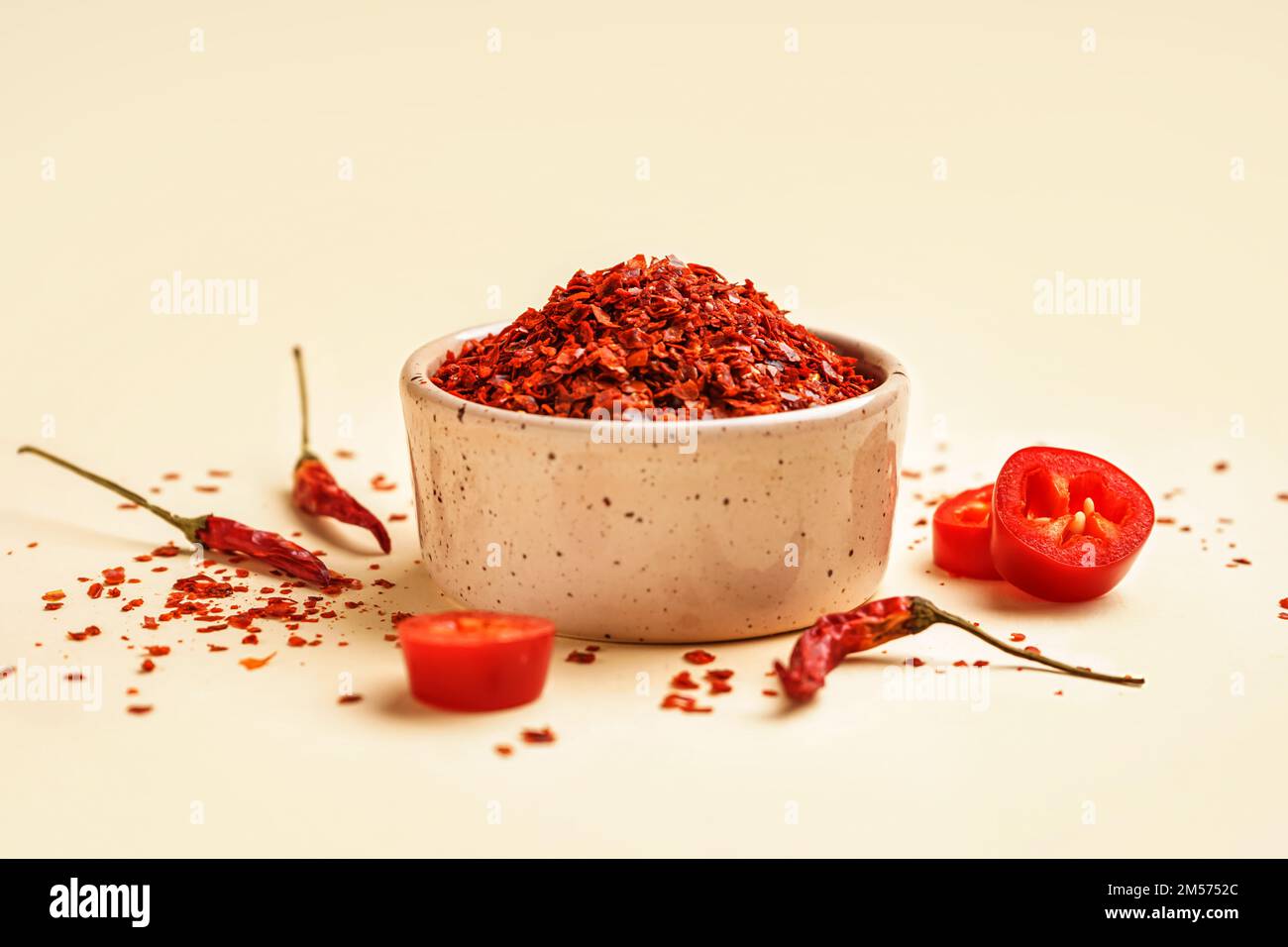 Bowl of chipotle chili flakes on color background Stock Photo - Alamy