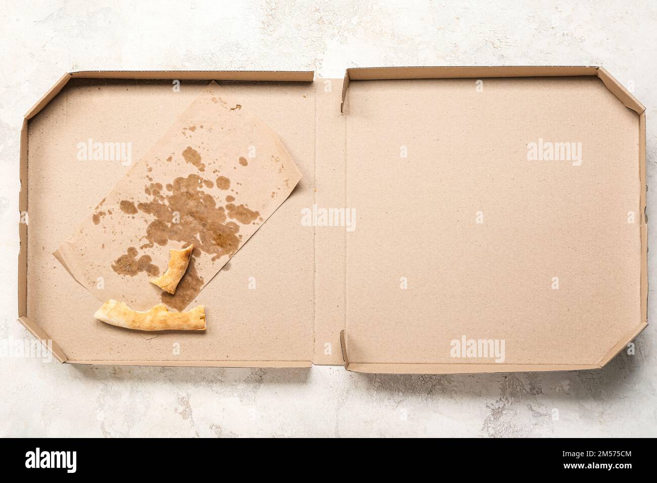 Cardboard greasy box with pizza leftovers on light background Stock ...
