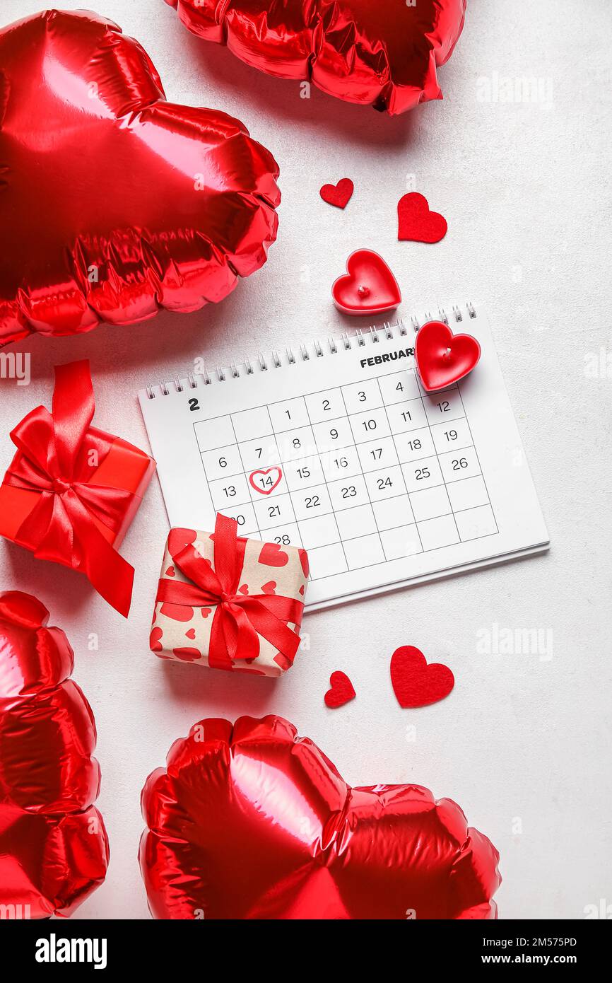 Calendar with marked date of Valentine's Day, candles, balloons and ...