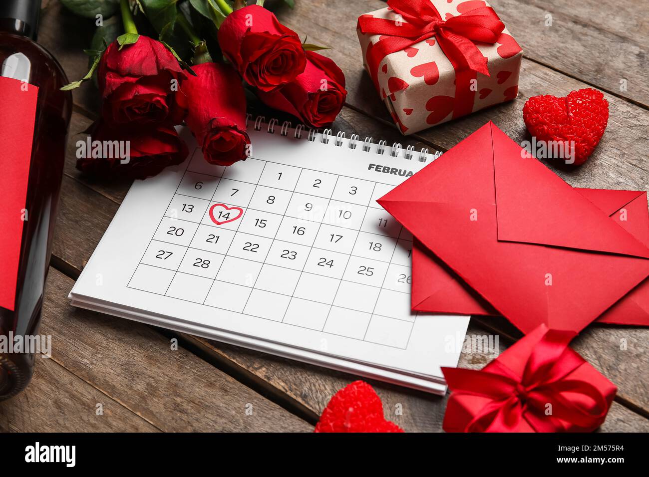 Calendar with marked date of Valentine's Day, envelopes and roses on ...