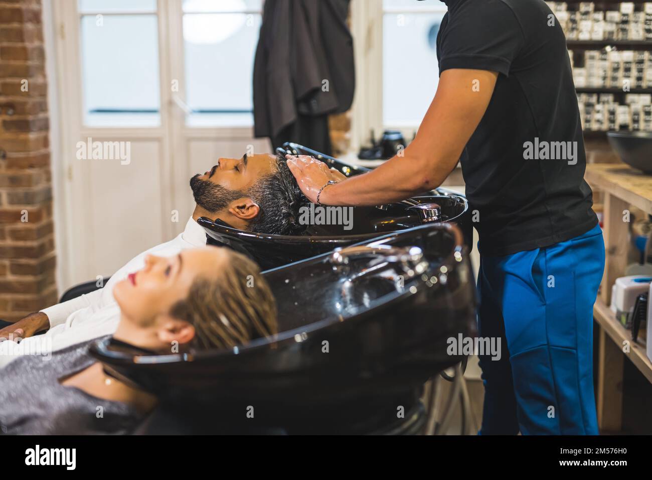 Couple visit at beauty salon. Two people using shampoo chairs in a ...