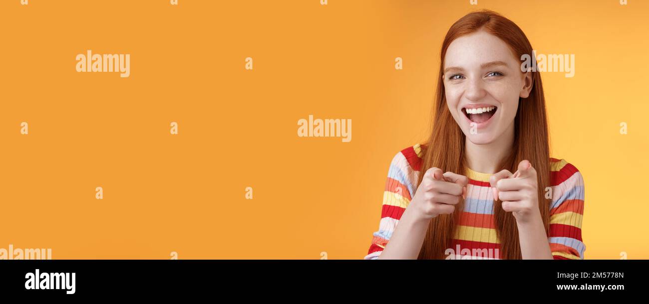 Enthusiastic carefree friendly redhead girl pointing finger-pistols ...