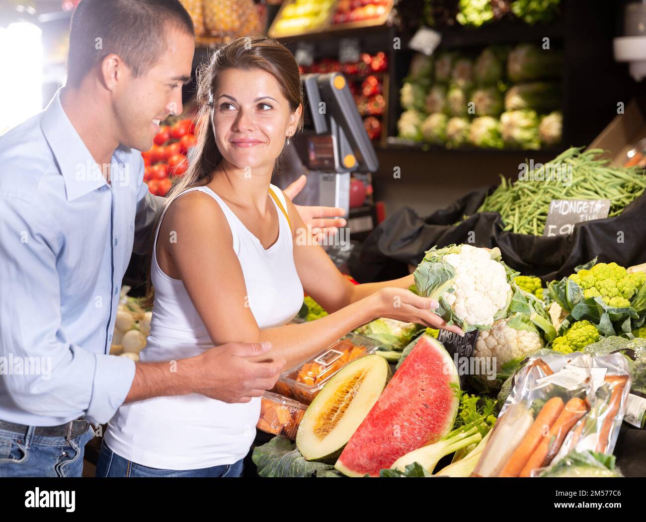 Cheerful young couple choosing fresh fruits and vegetables Stock Photo ...