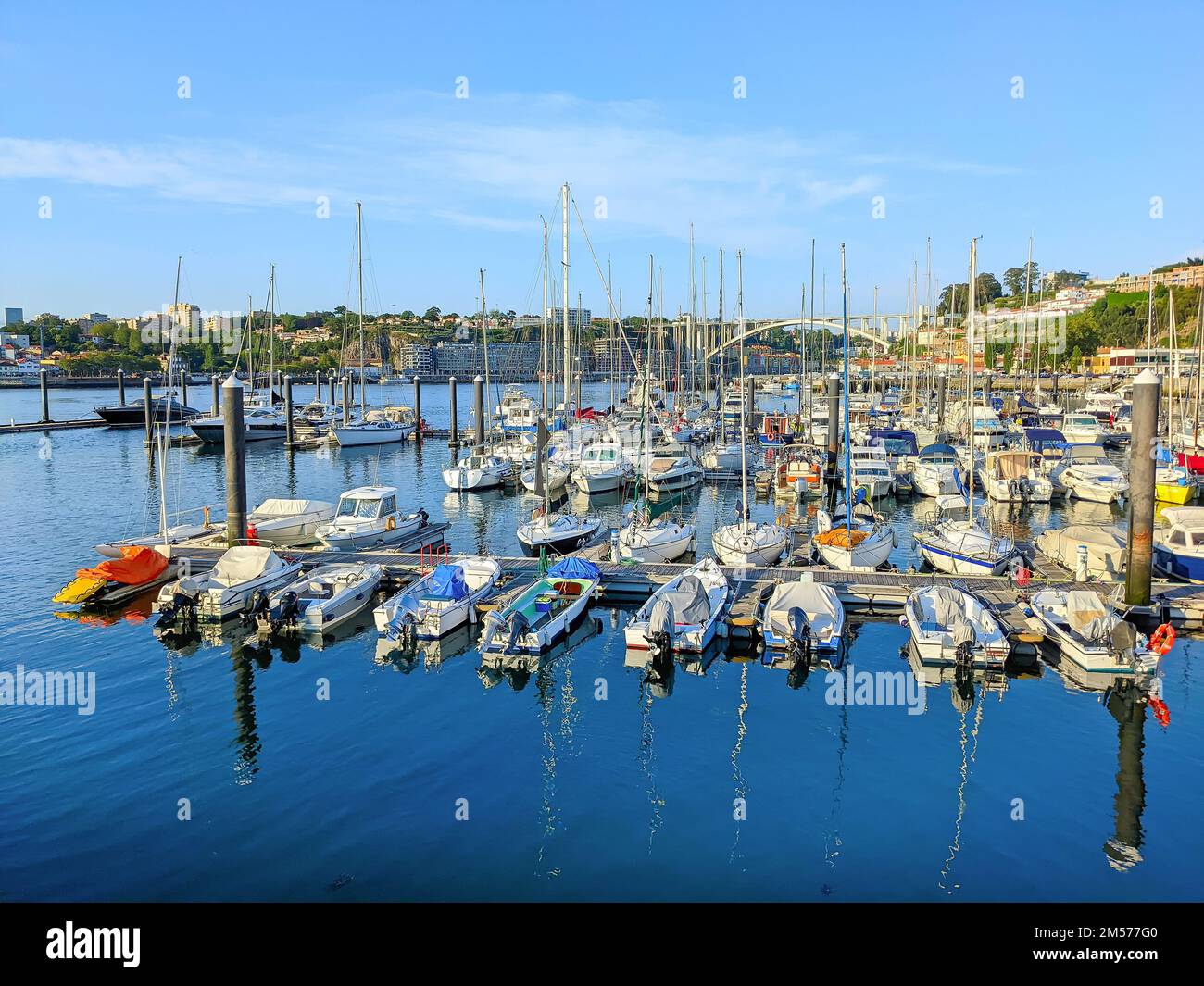 Motorboats and yachts moored by pier in marina, Arrabida bridge in ...