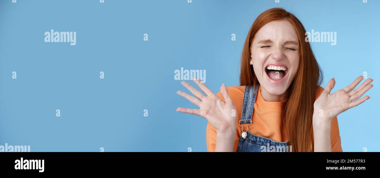 Positive carefree triumphing young attractive redhead girl scream out ...