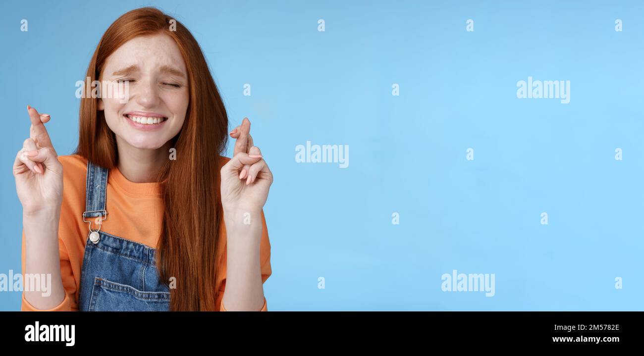 Sincere hopeful cute redhead girl believe miracle close eyes faithfully ...