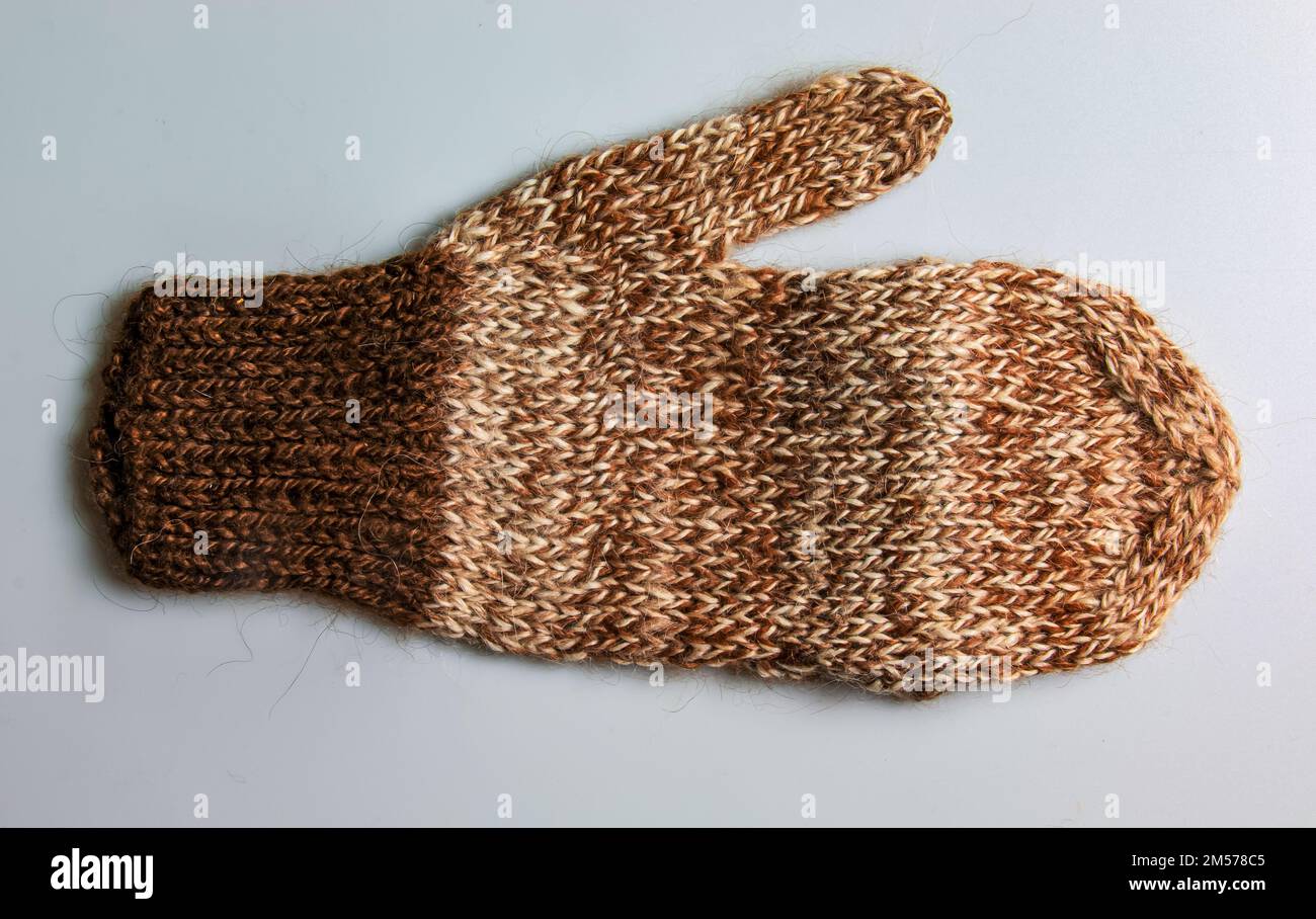 Handmade brown-beige mittens from Argentinean merino wool on a white ...
