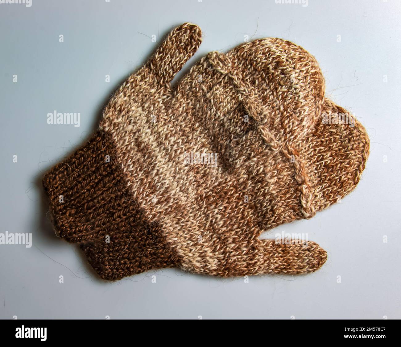 Handmade brown-beige mittens from Argentinean merino wool on a white ...