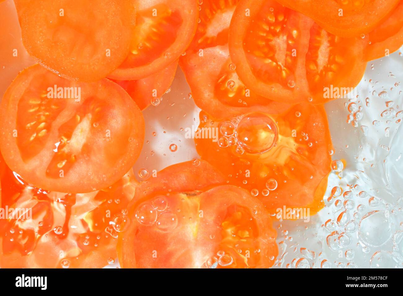 Slices of tomato in water on white background. Tomato close-up in ...