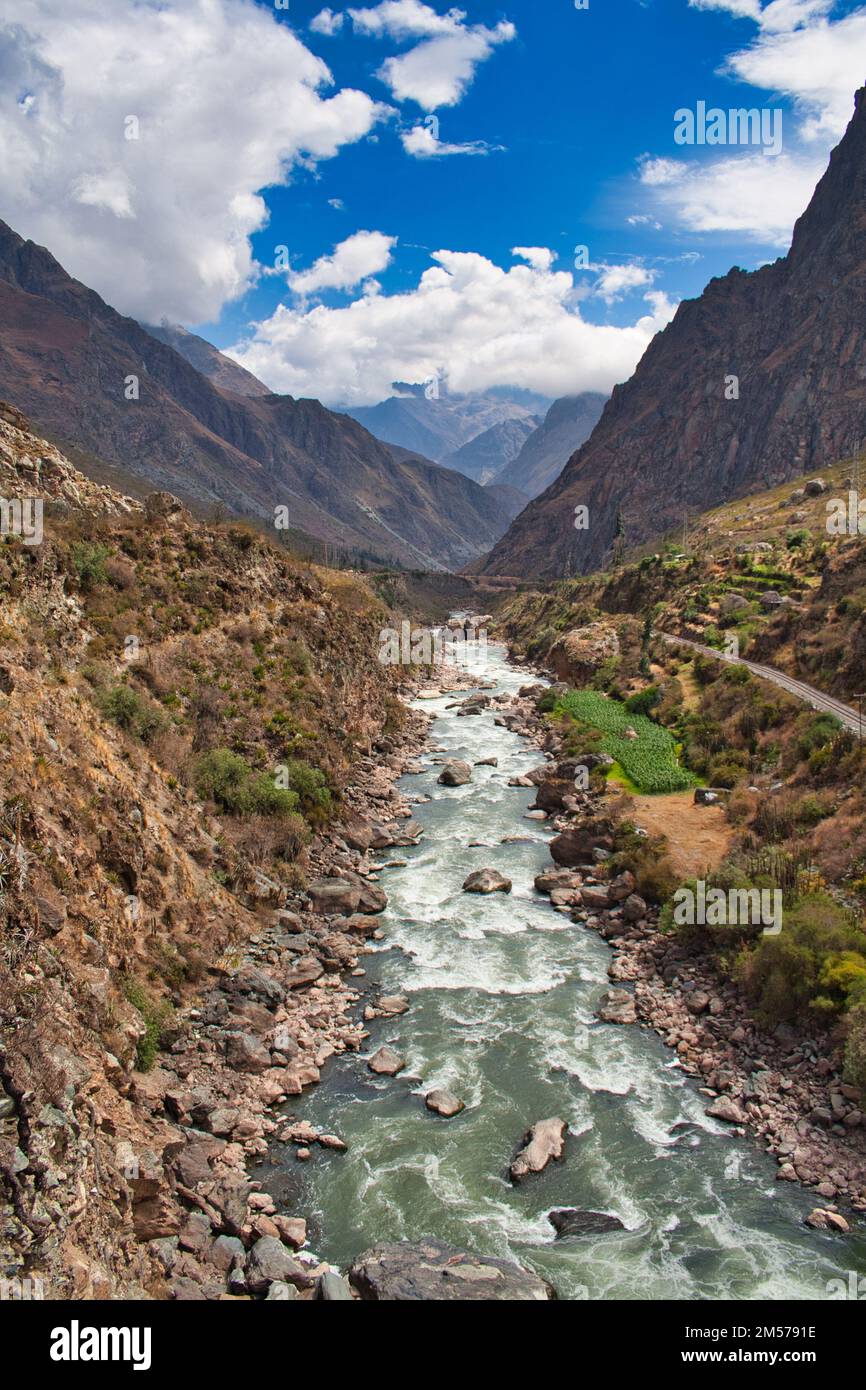 A vertical aerial view of a narrow lake covered surrounded by mountain ...
